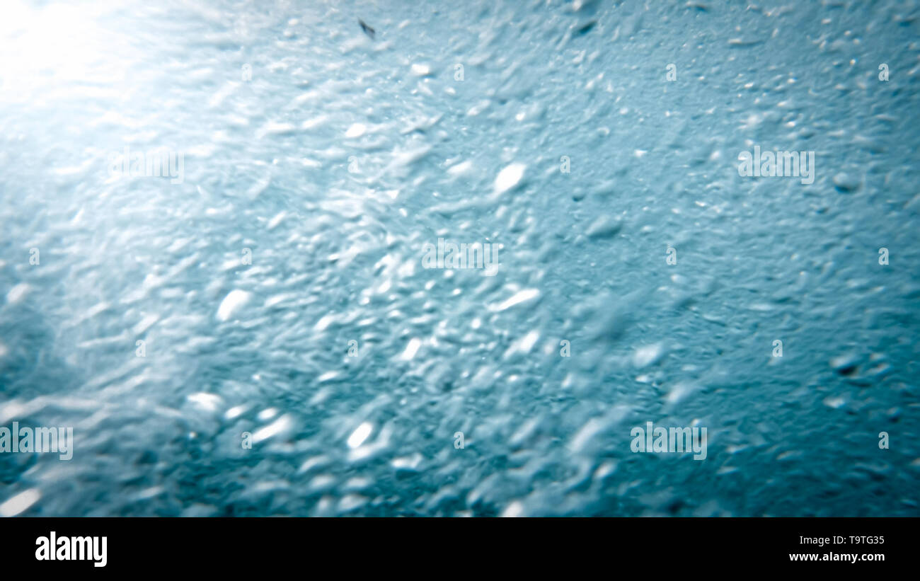 Closeup image of air bubbles in sea water. Shot from the inside of ...