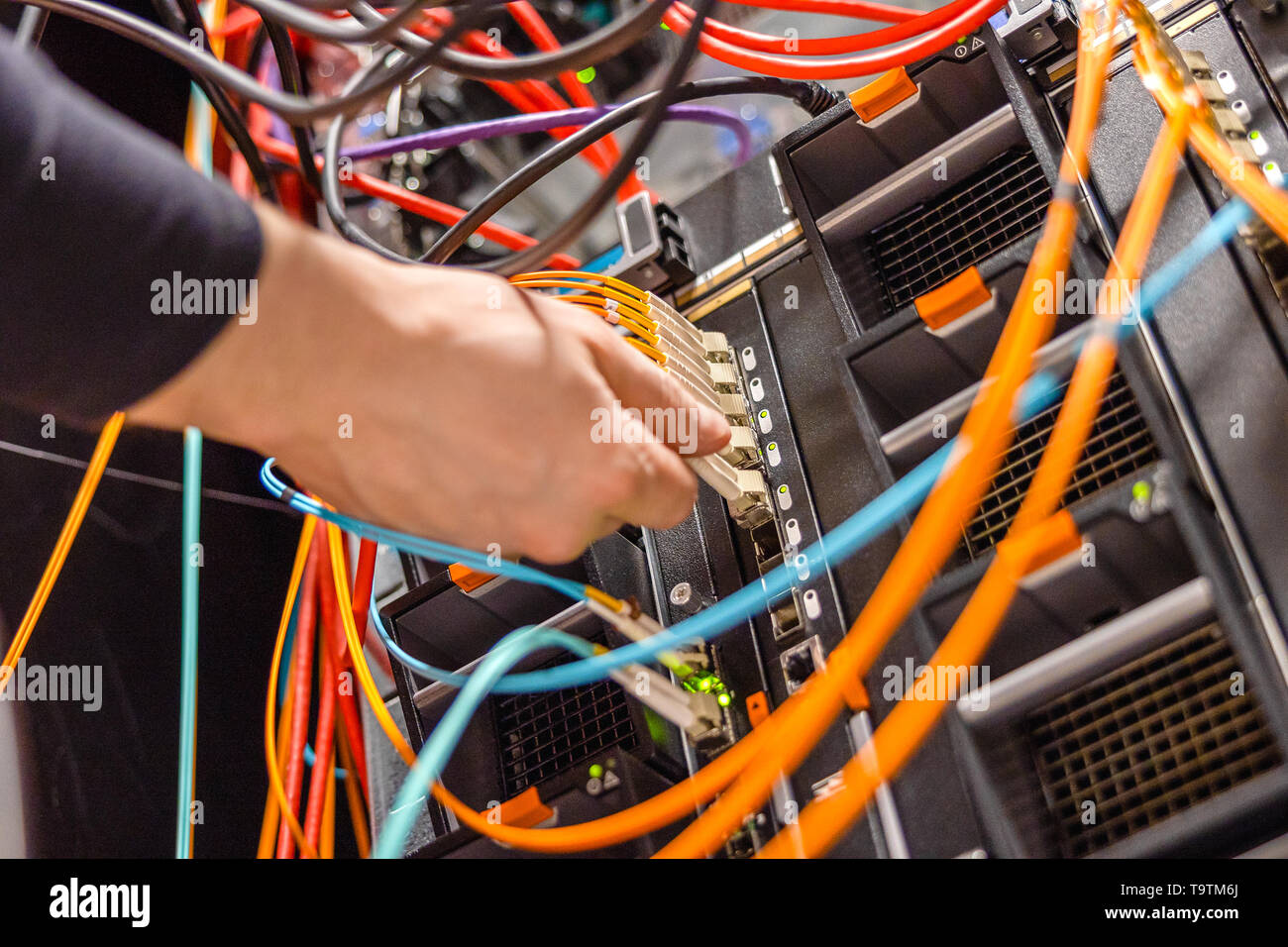 Male Technician Plugging Fiber Channel Network Cable In Blade Server ...