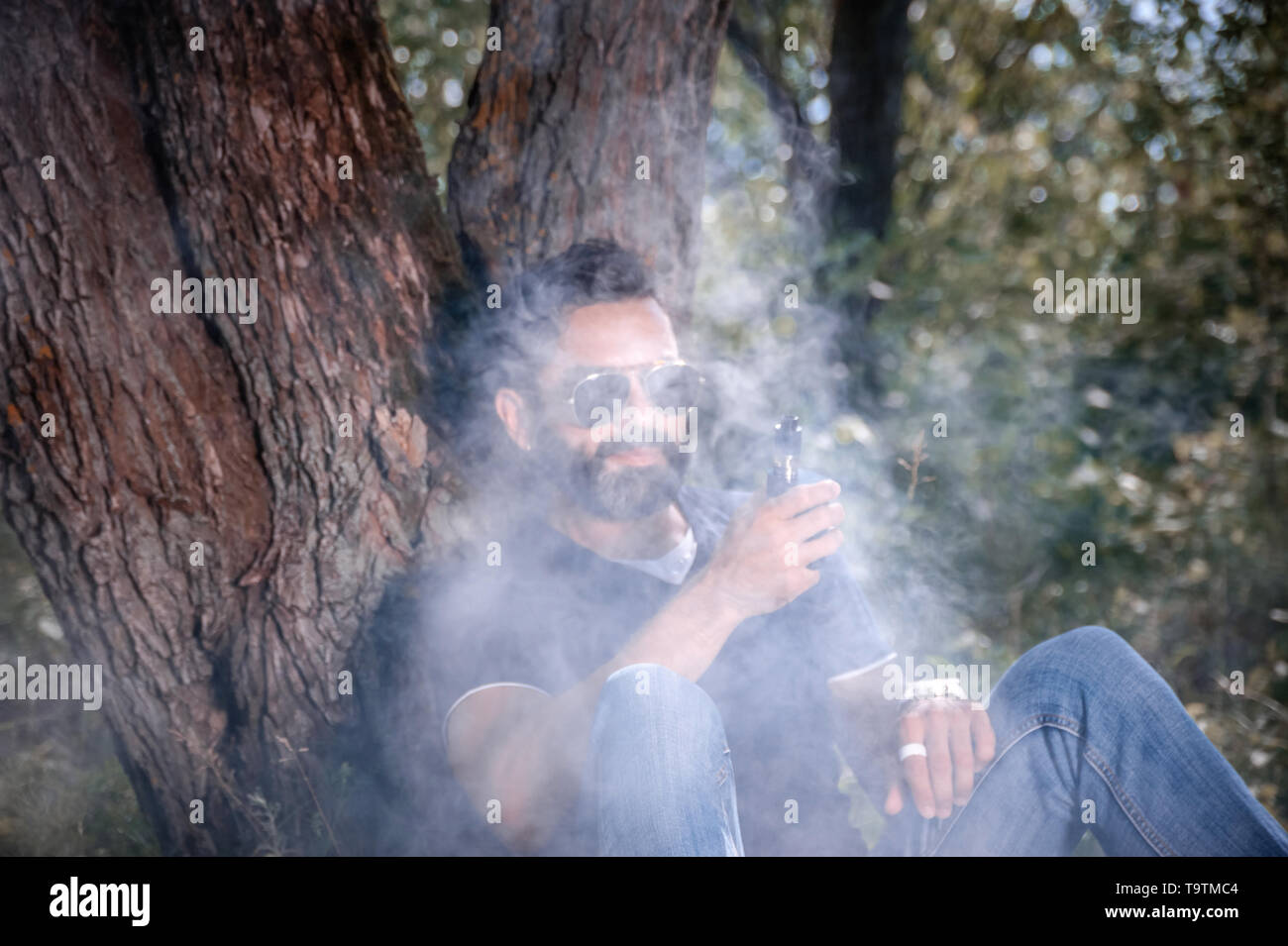 Modern smoker enjoying an e-cigarette in the fresh air. Smoking ...