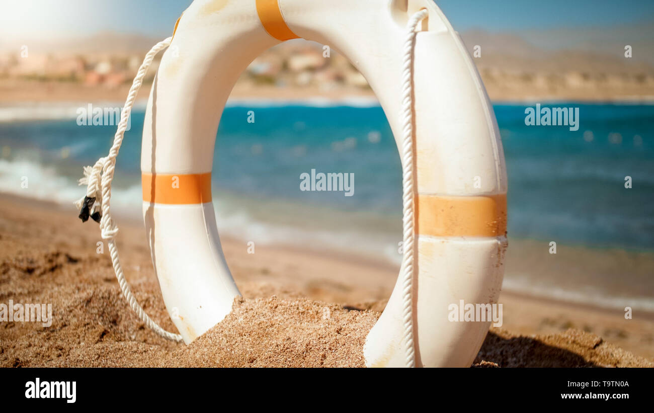 Closeup image of white plastic life saving ring on the sea beach at ...
