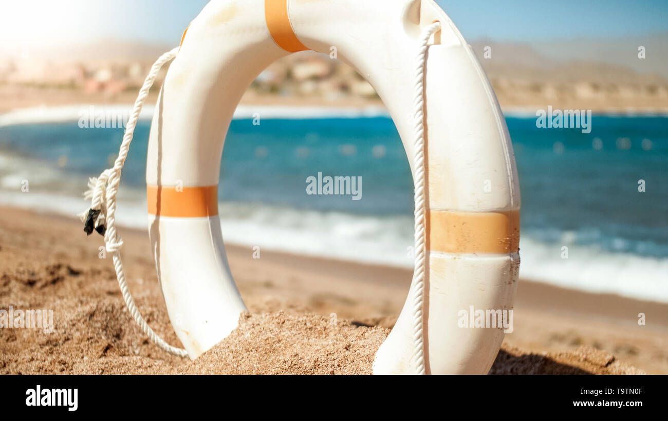 Beautiful image of white plastic life saving ring standing on the sandy ...