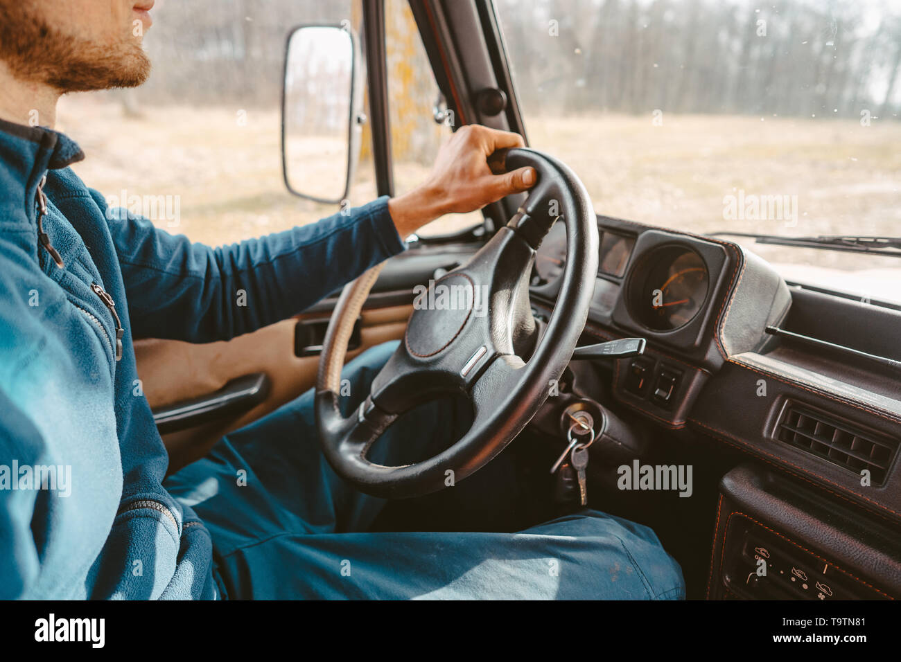 man driving suv car by forest trail road Stock Photo - Alamy