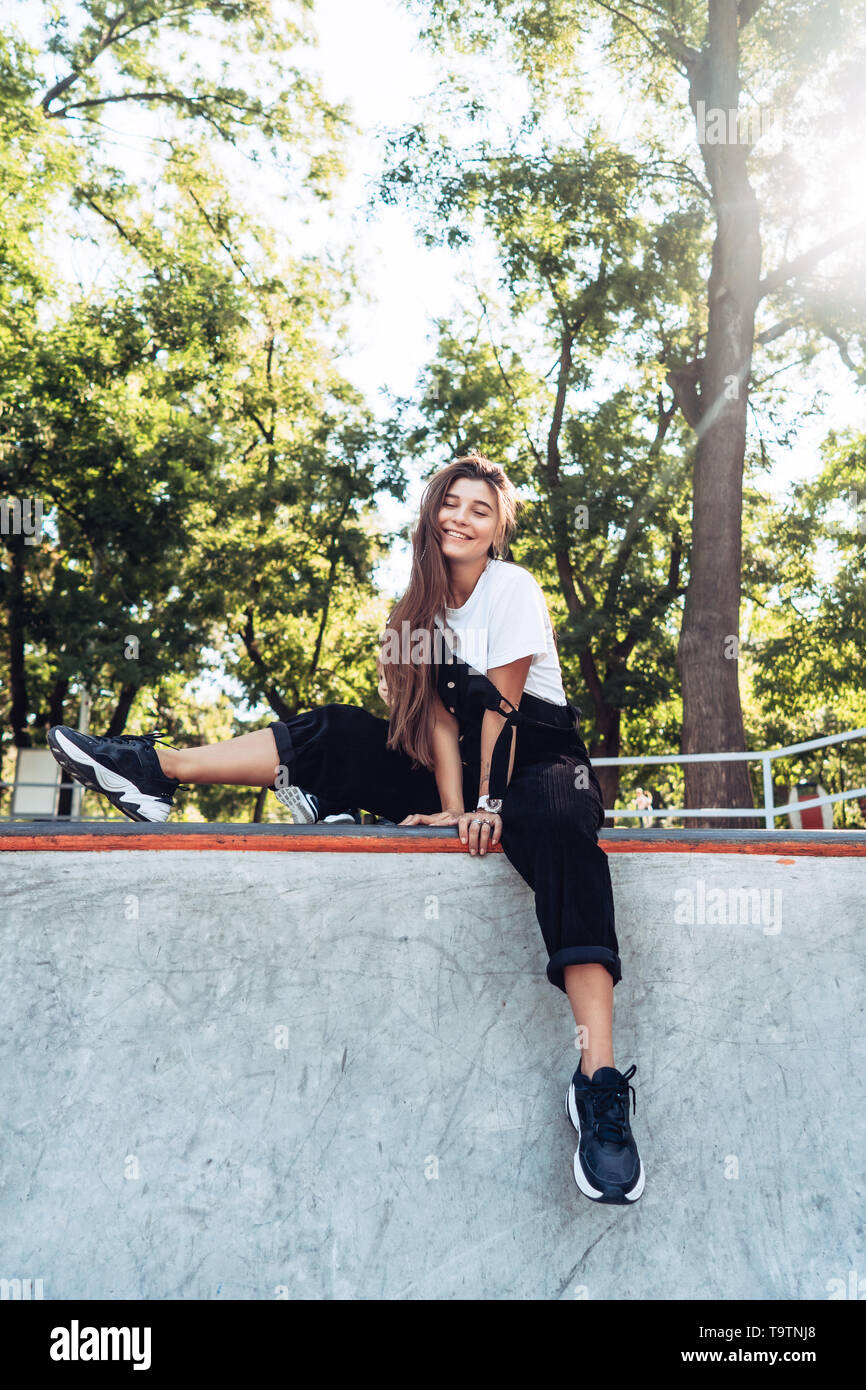 Beautiful young hipster girl sitting on the edge of a ramp Stock Photo ...