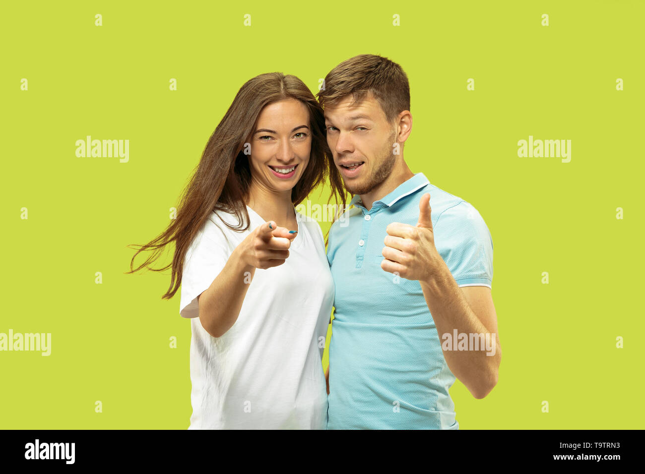 Beautiful young couple's half-length portrait isolated on green studio ...
