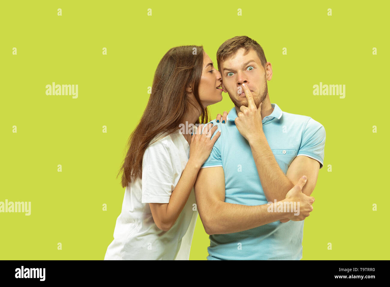 Beautiful young couple's half-length portrait isolated on green studio ...