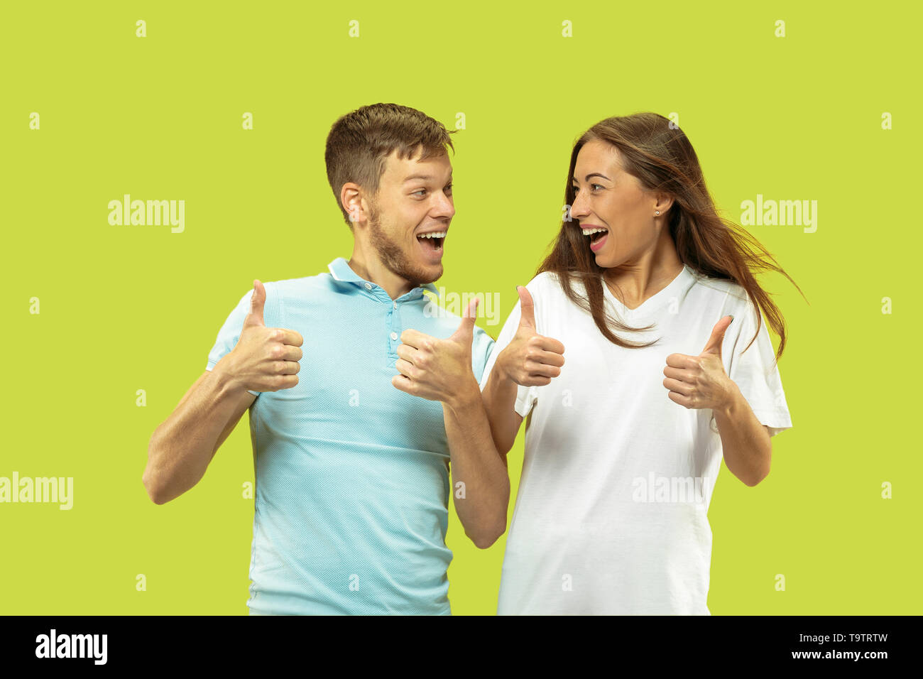 Beautiful young couple's half-length portrait isolated on green studio ...