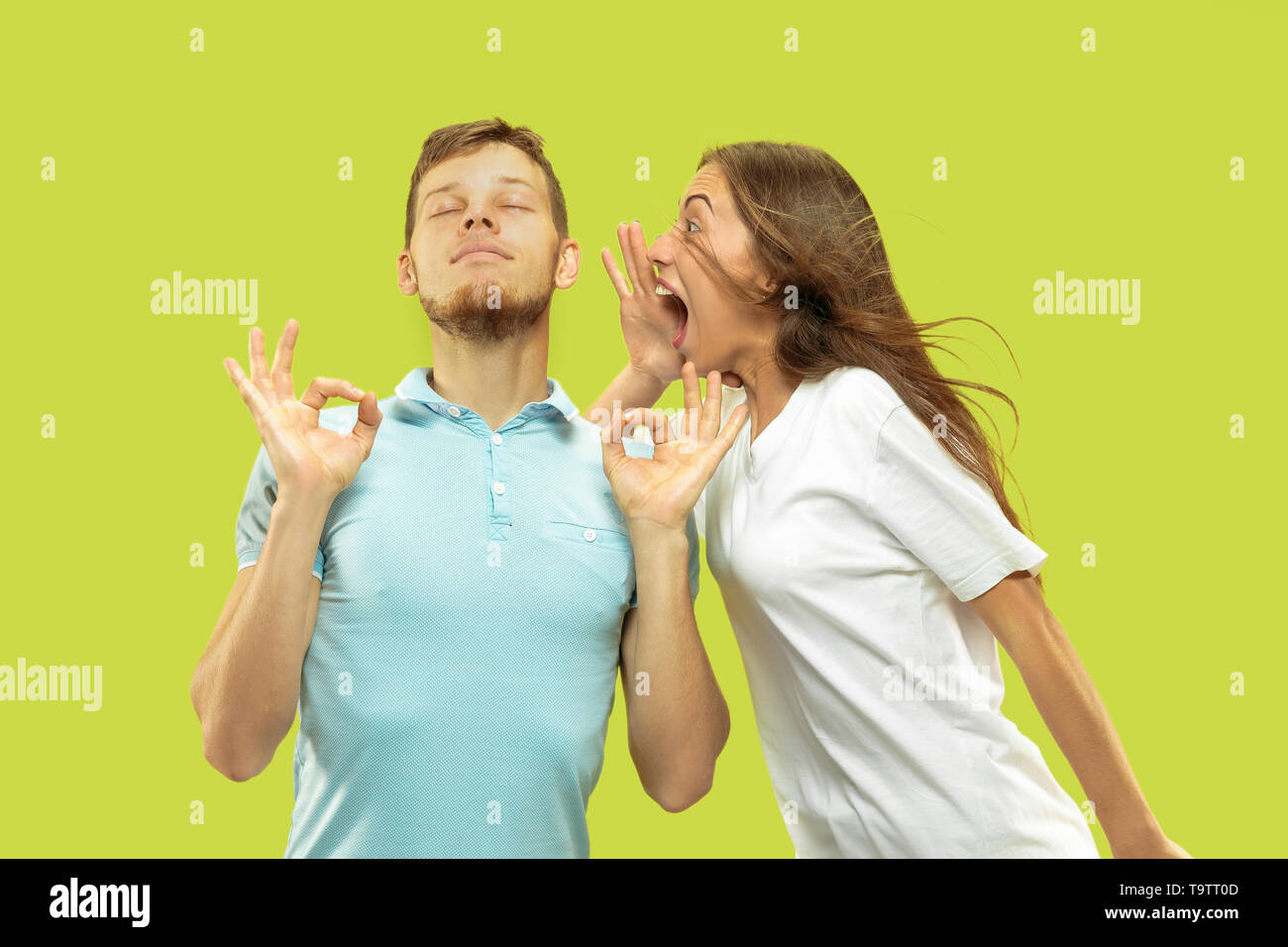 Beautiful young couple's half-length portrait isolated on green studio ...
