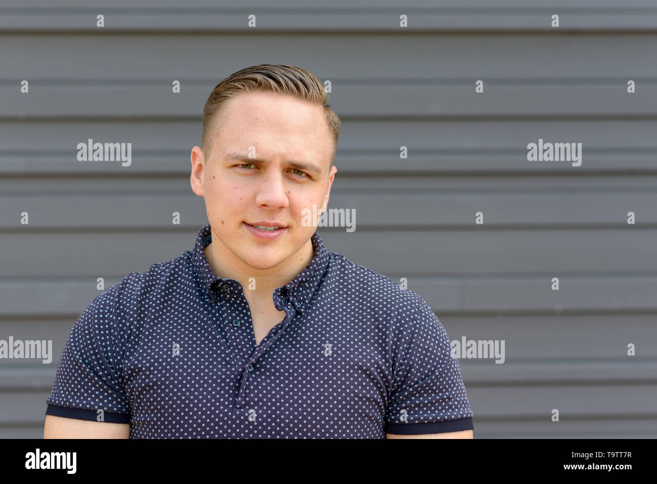 Sceptical young man staring at the camera with in intense frown in ...