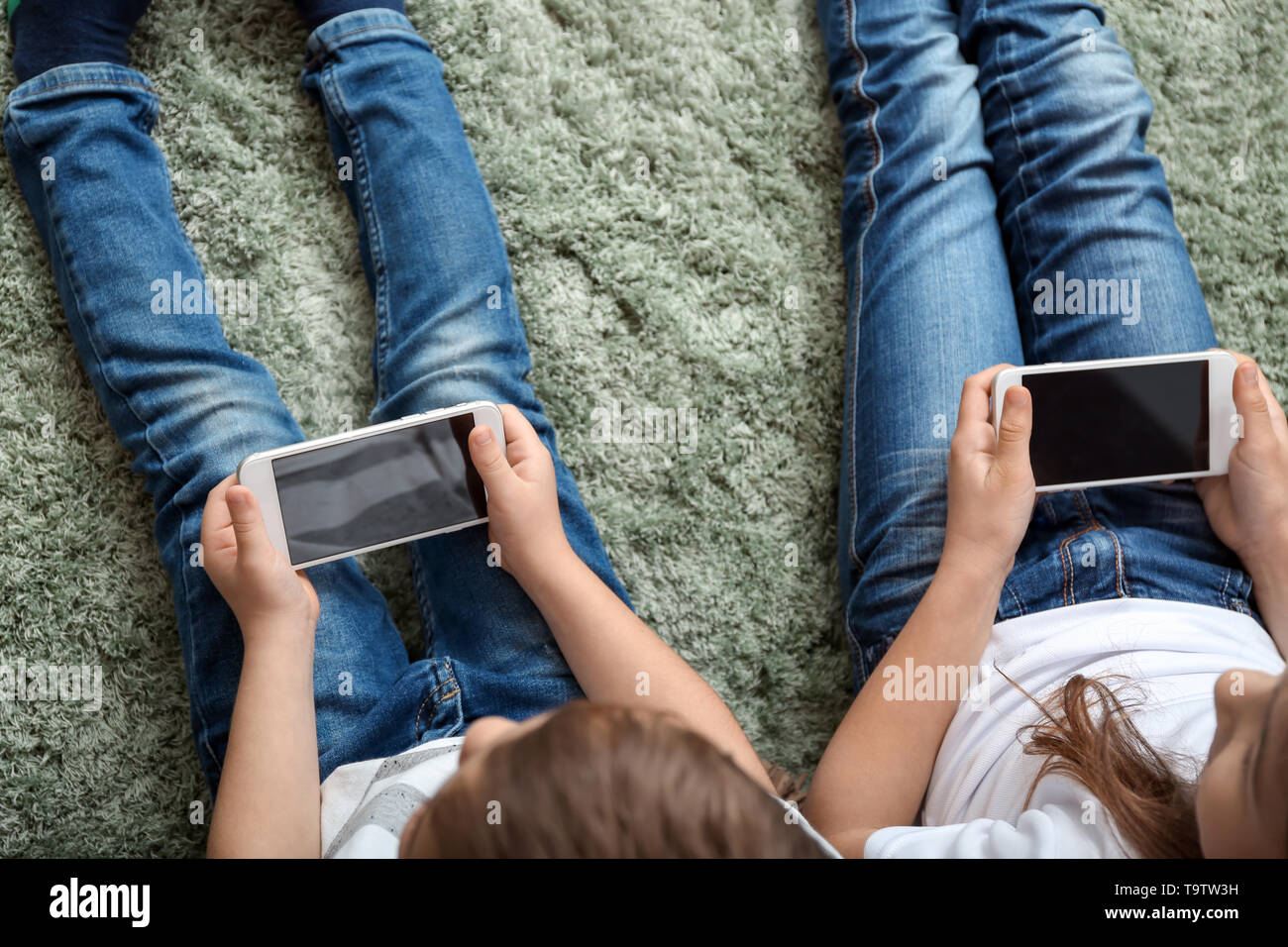 Cute little children playing with smartphones at home Stock Photo - Alamy