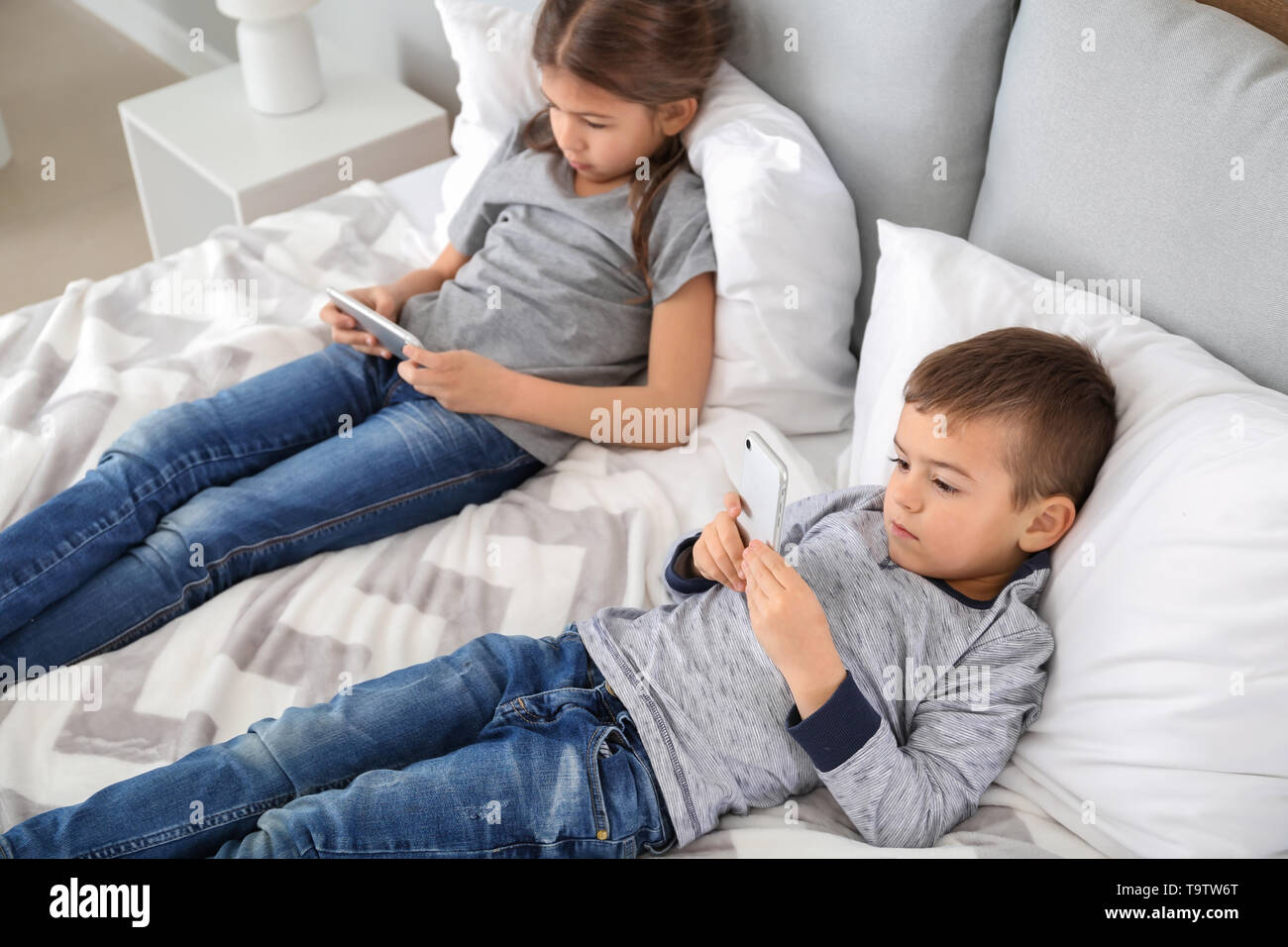 Cute little children playing with smartphones at home Stock Photo - Alamy