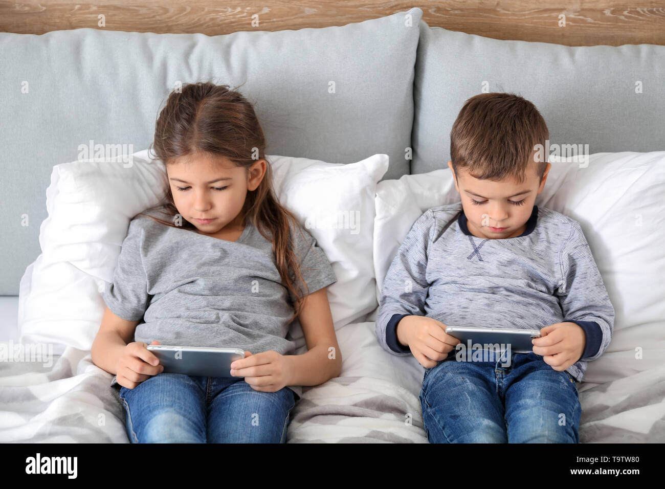 Cute little children playing with smartphones at home Stock Photo - Alamy
