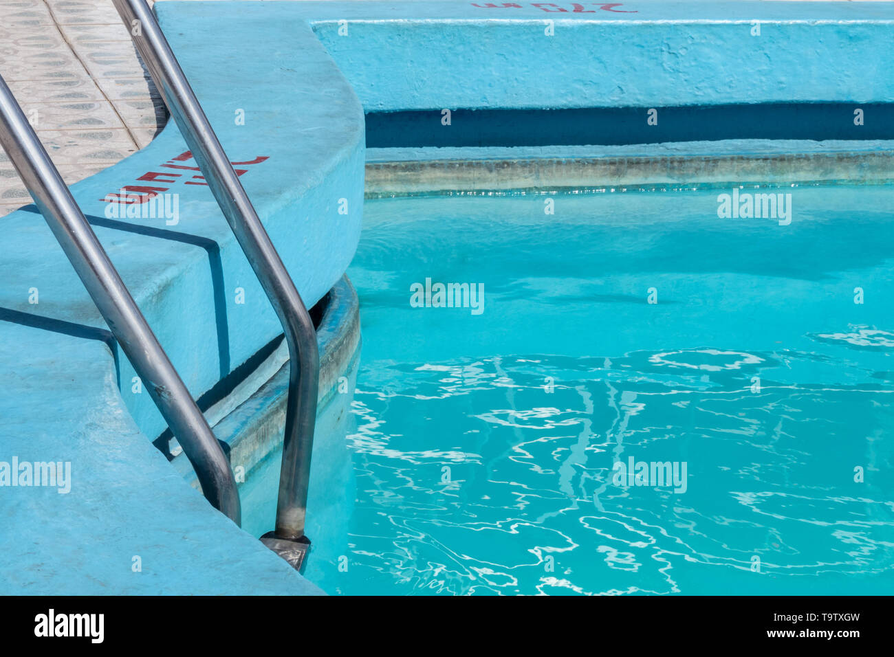 Poolside in Havana, blue pool with rippled water and ladder Stock Photo ...