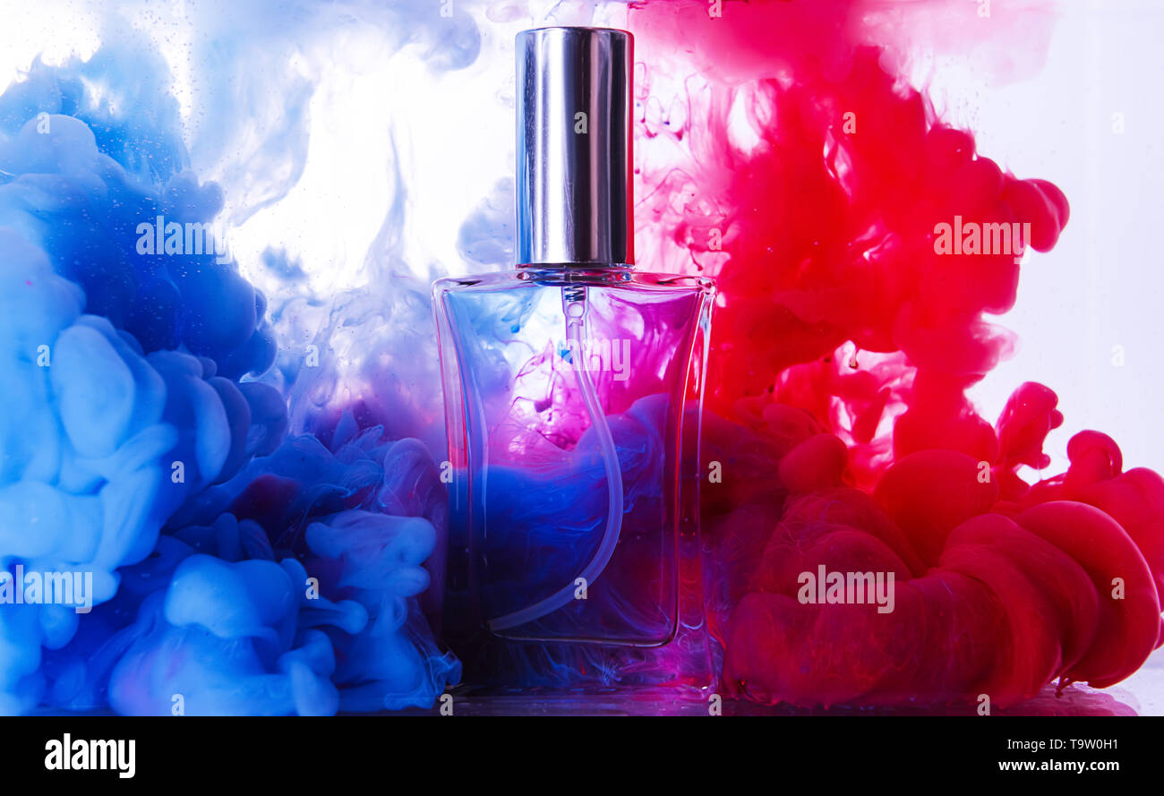 Bottle of perfume in color smoke Stock Photo - Alamy