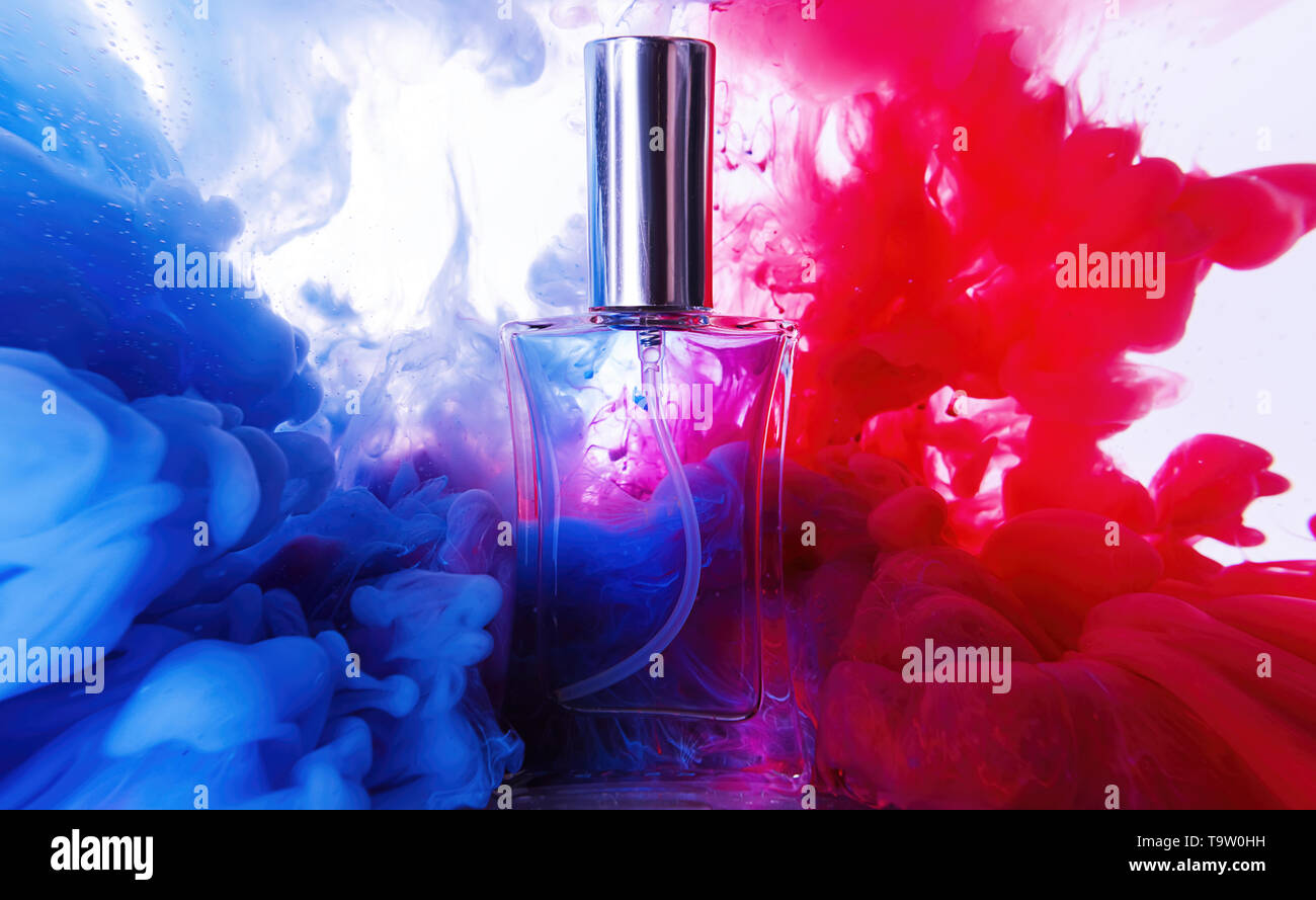 Bottle of perfume in color smoke Stock Photo - Alamy