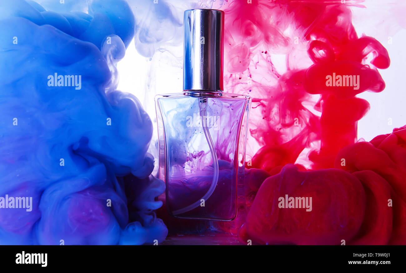Bottle of perfume in color smoke Stock Photo - Alamy