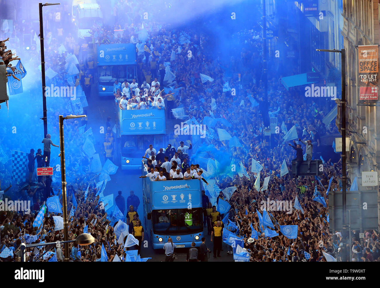 The Manchester City players and staff on the buses pass the crowds of ...
