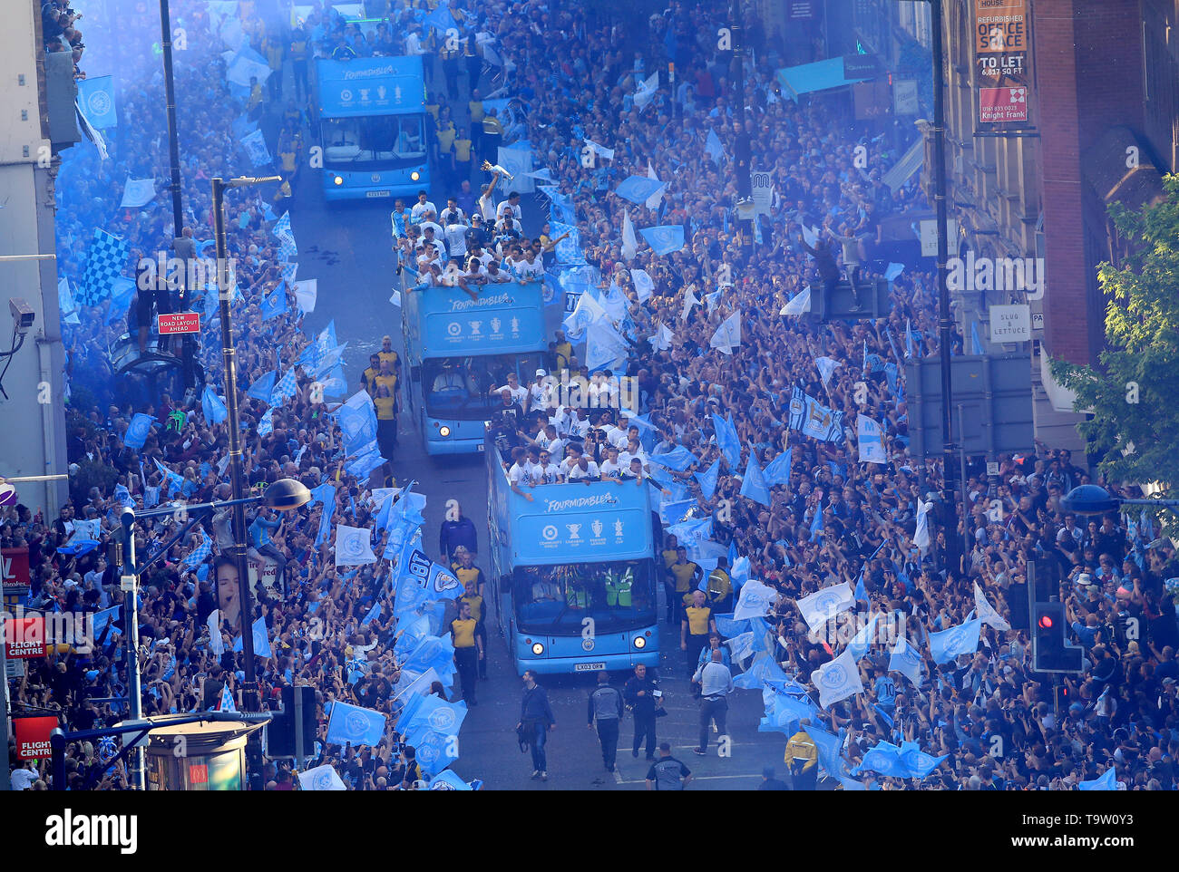 The Manchester City players and staff on the buses pass the crowds of ...