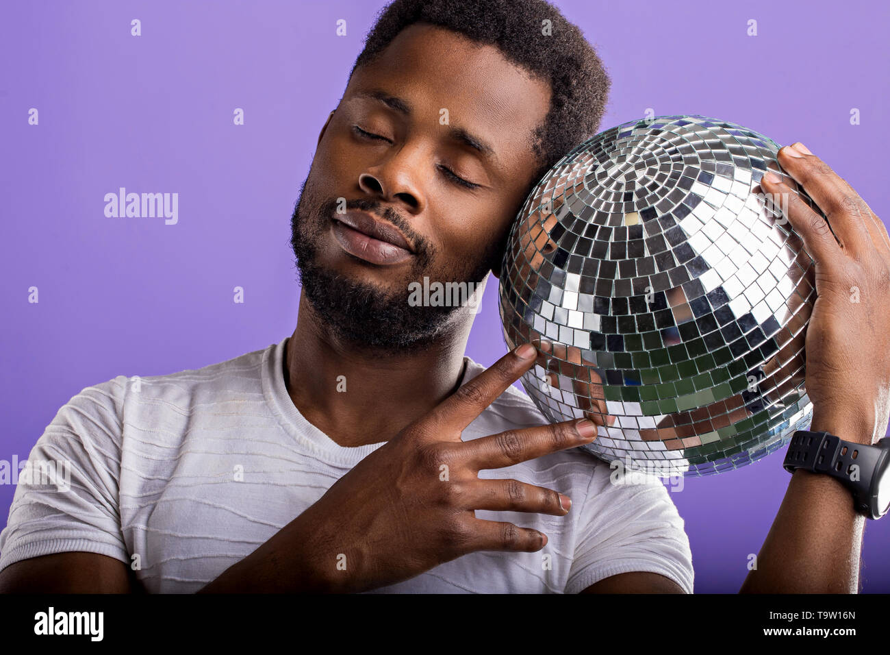 Handsome relaxed unshaven african american man holding shining disco ...