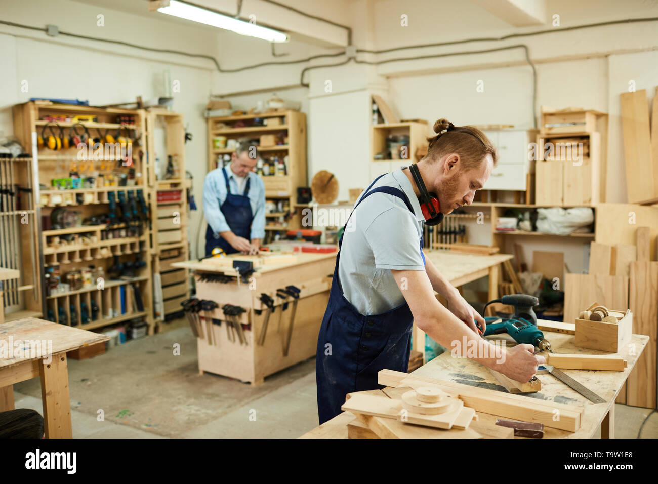 Side view portrait of two carpenters working with wood standing at ...