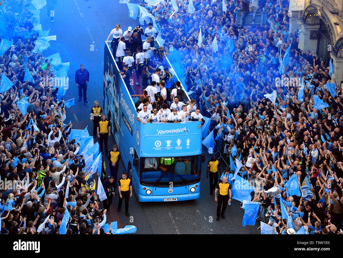 The Manchester City players and staff on the buses pass the crowds of ...
