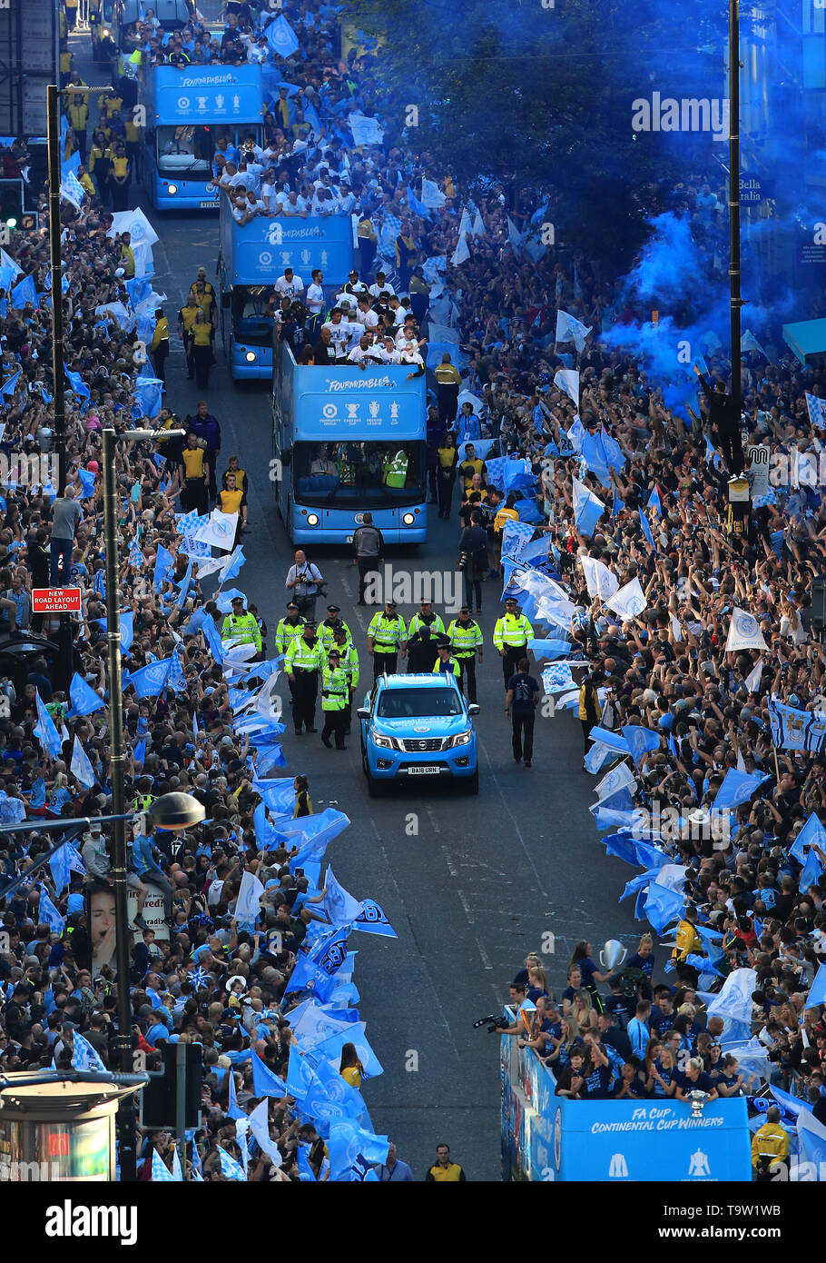 The Manchester City players and staff on the buses pass the crowds of ...
