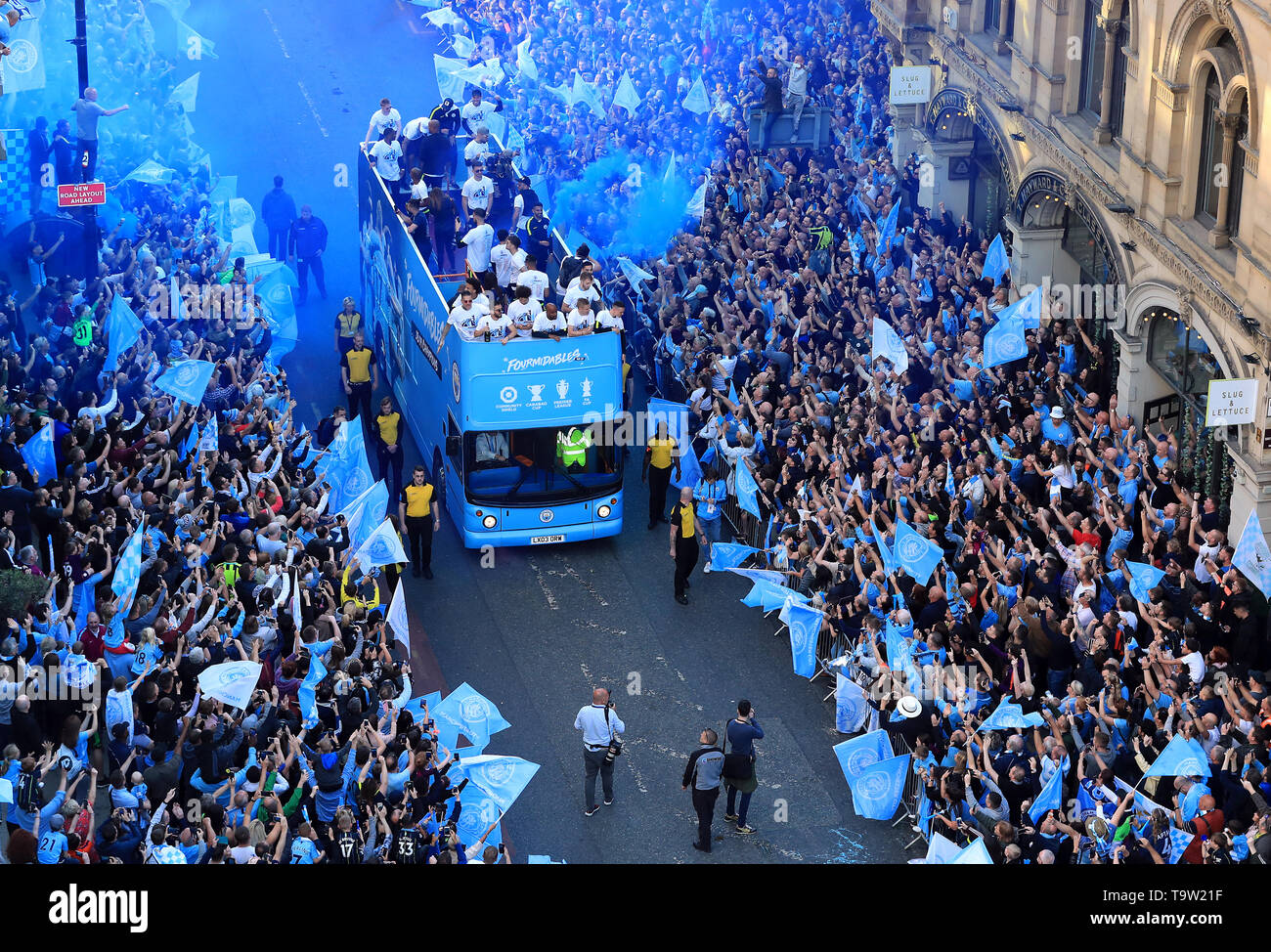 The Manchester City players and staff on the buses pass the crowds of ...