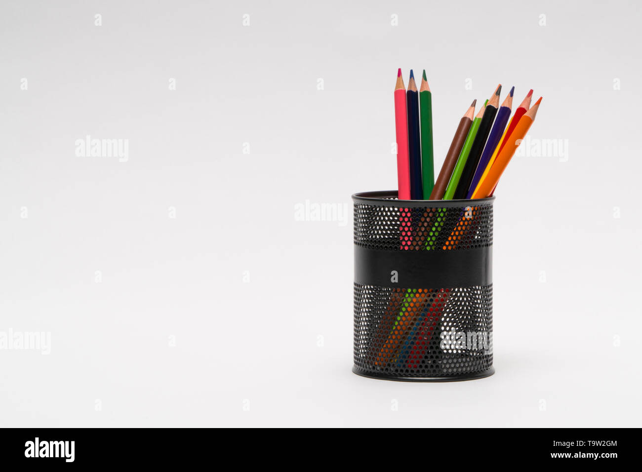 set of colored pencils in a basket on a white background, isolated ...