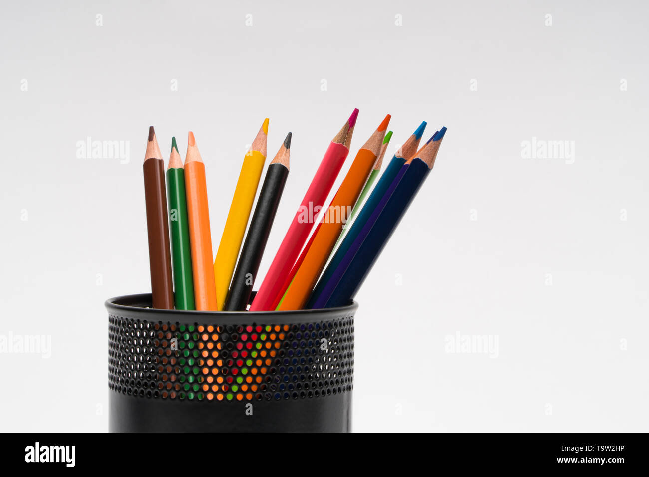set of colored pencils in a basket on a white background, isolated ...