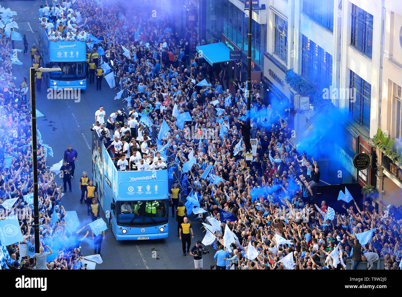 The Manchester City players and staff on the buses pass the crowds of ...