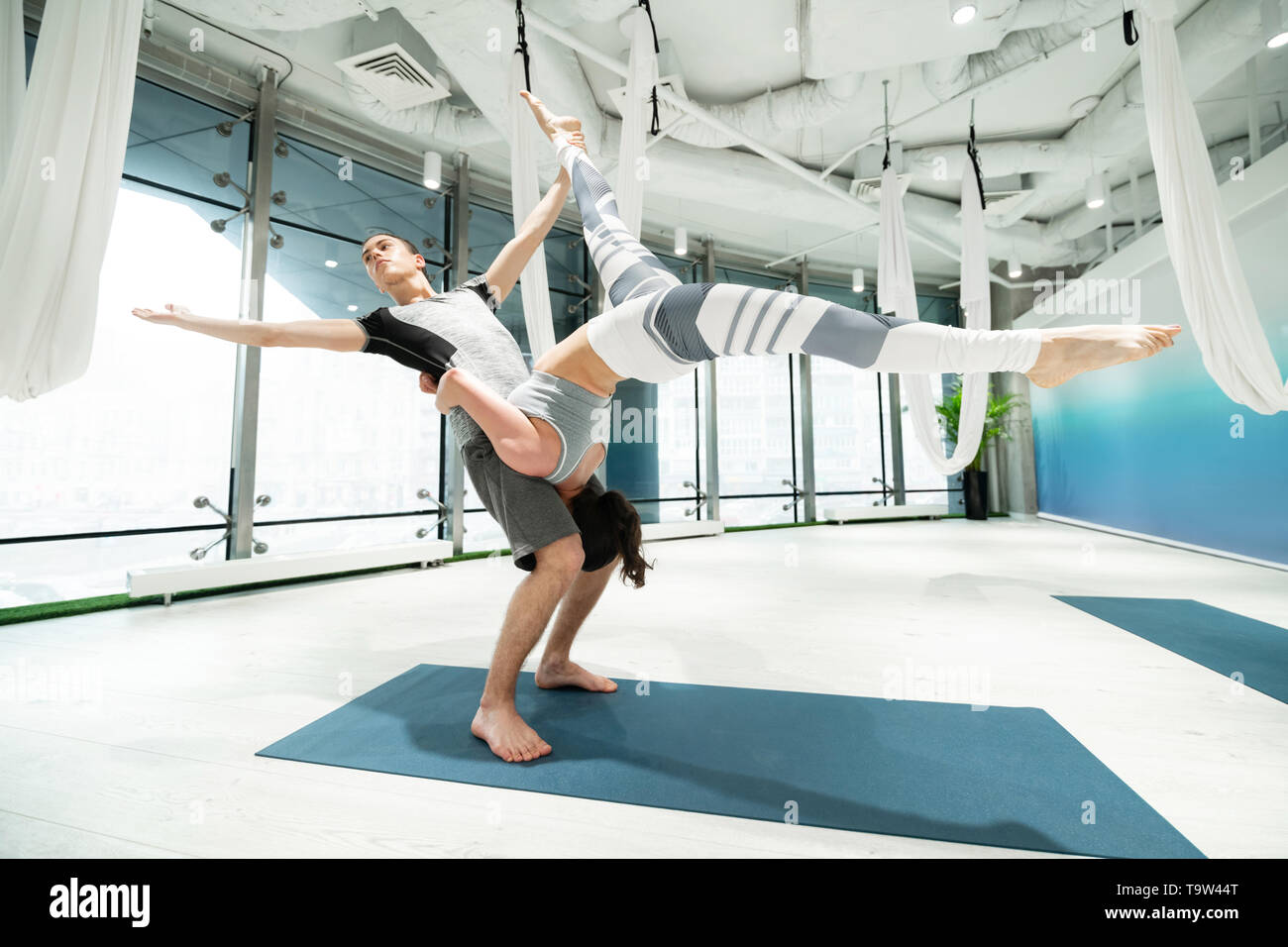 Man lifting his fit girlfriend while practicing yoga together Stock ...