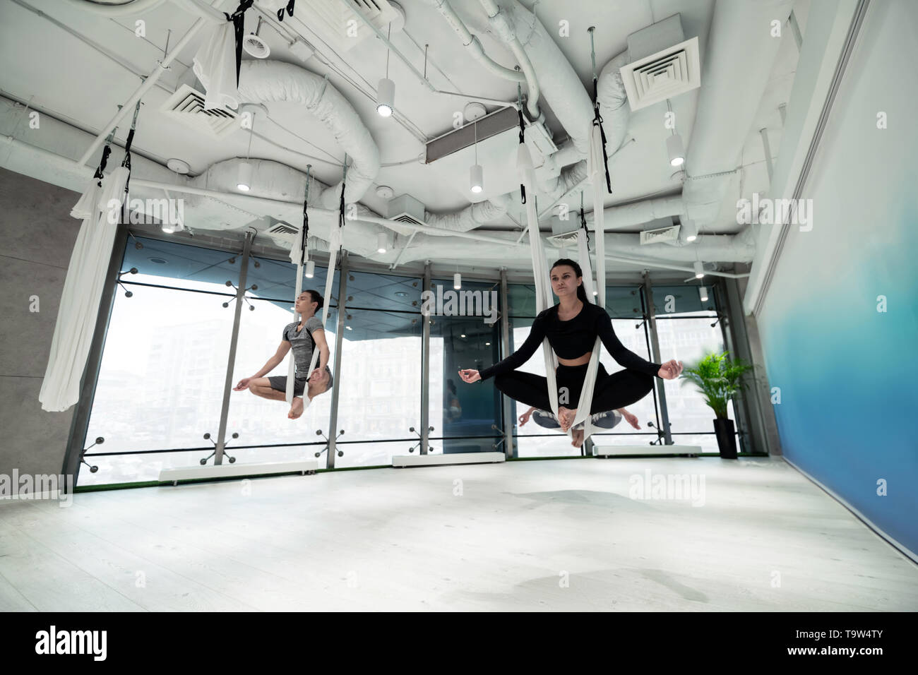 Women and man feeling amazing while doing flying yoga Stock Photo - Alamy