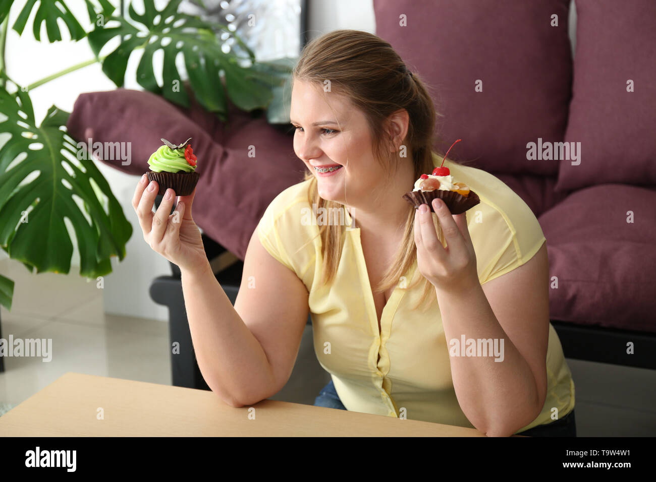 Beautiful plus size girl with sweet cakes at home. Concept of body ...