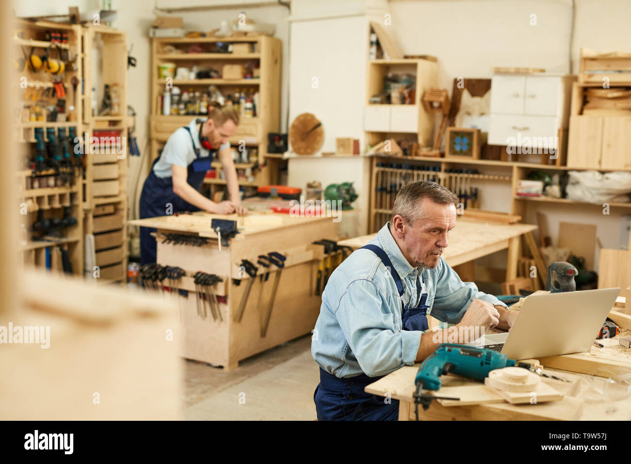 High angle portrait of two carpenters working with wood standing at ...