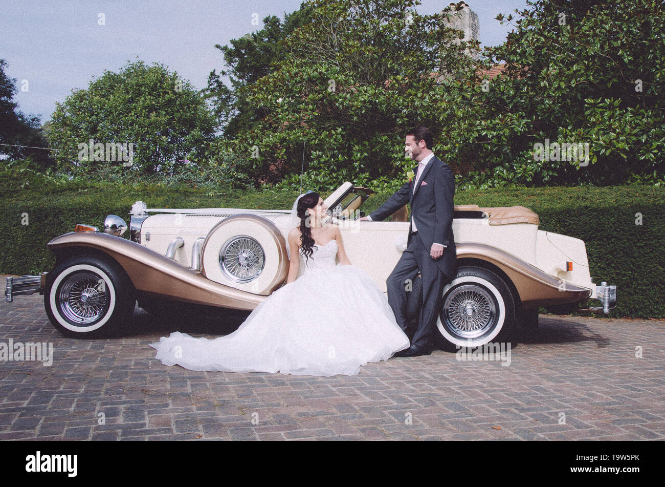 Bride and Groom with the wedding car Stock Photo - Alamy