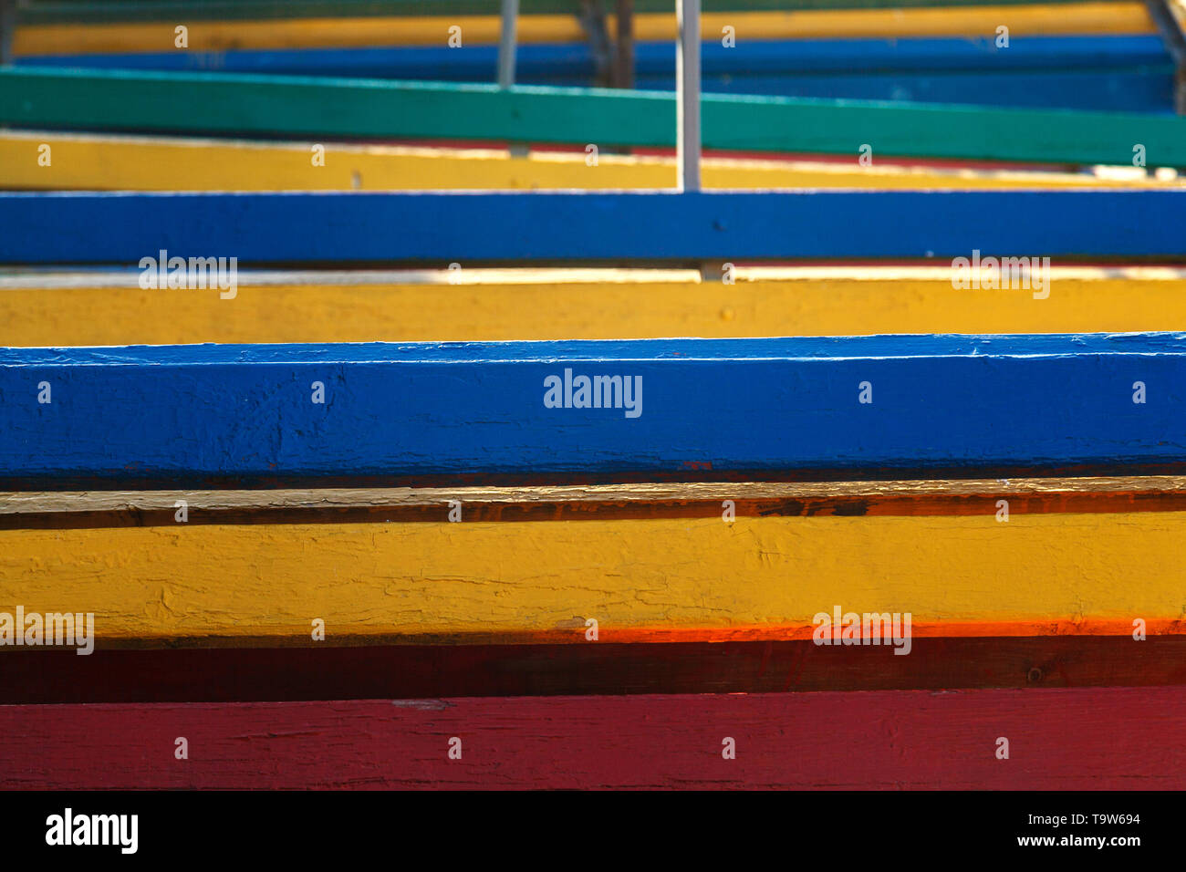 Colorful beach benches stacked in a pile, close-up. Abstract background ...