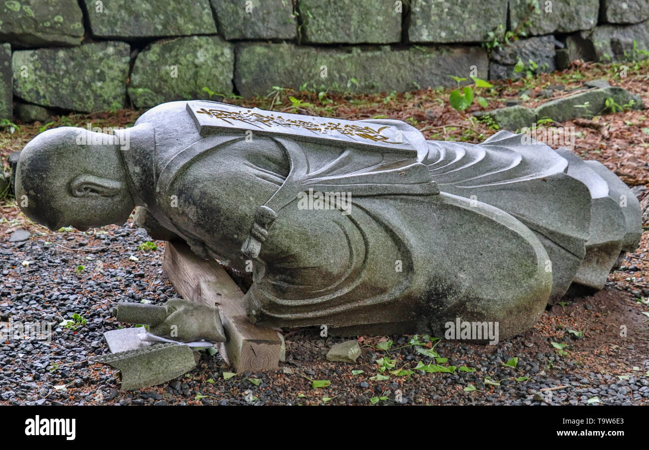 Dropped down, fallen buddhist monk granite stone statuesque in a Temple ...