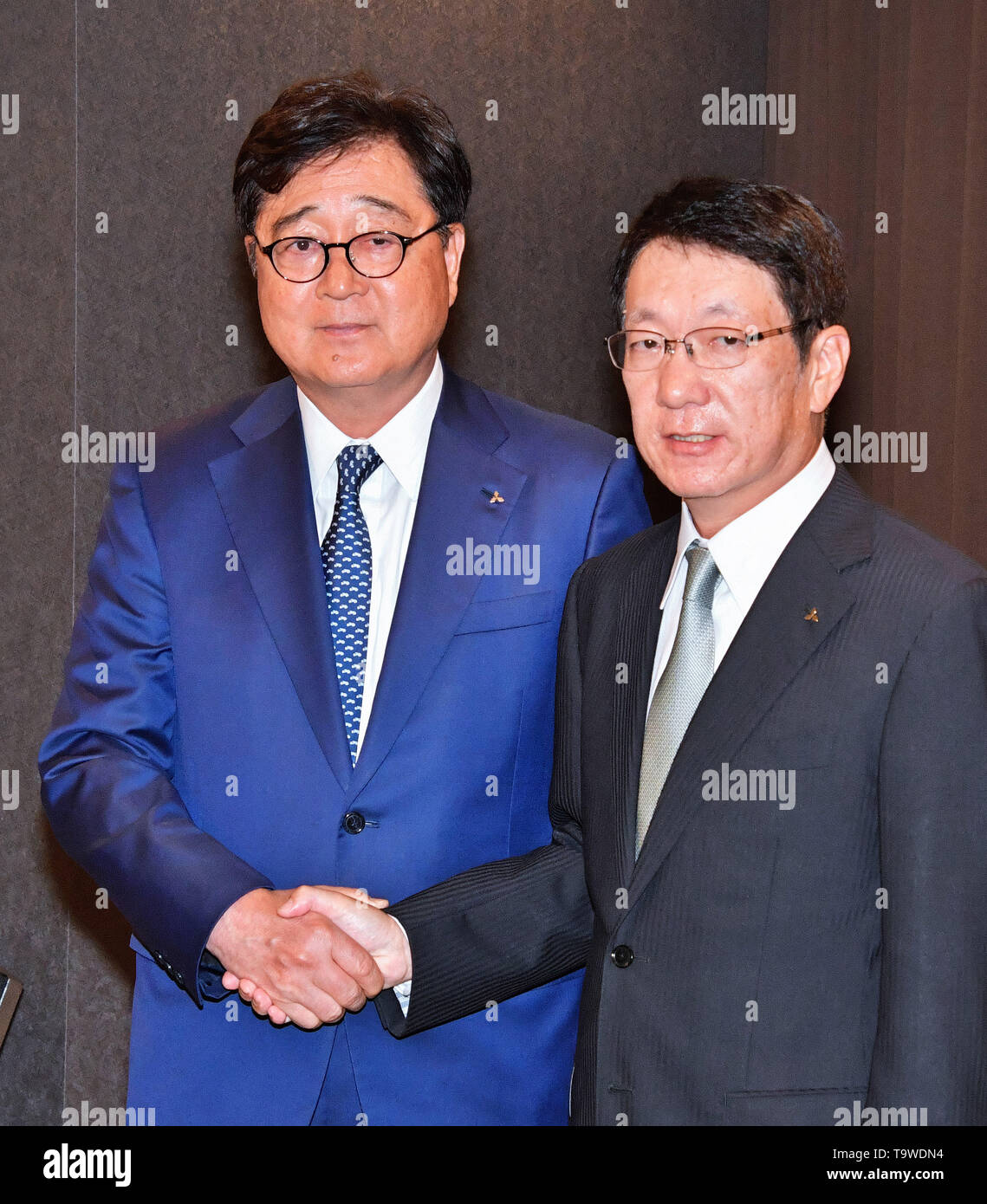 Chairman of Mitsubishi Motors Osamu Masuko (L) shakes hands with New ...
