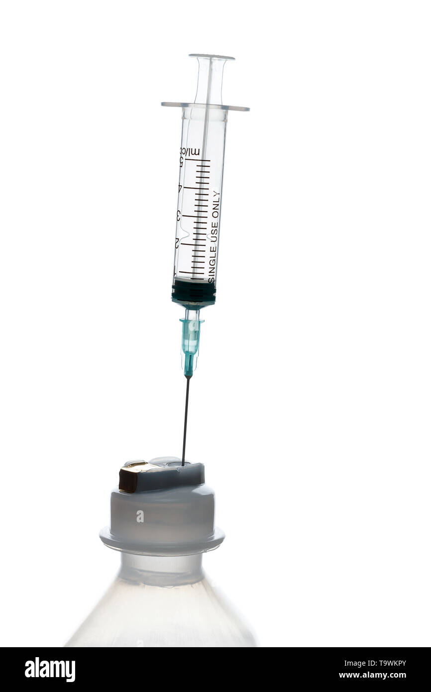 Empty syringe for injection with a neck of a plastic bottle on a white ...