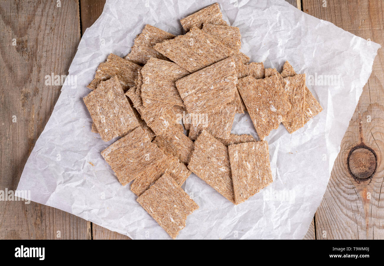 Healthy corn airy crispbreads on white wrapping paper on old wooden ...