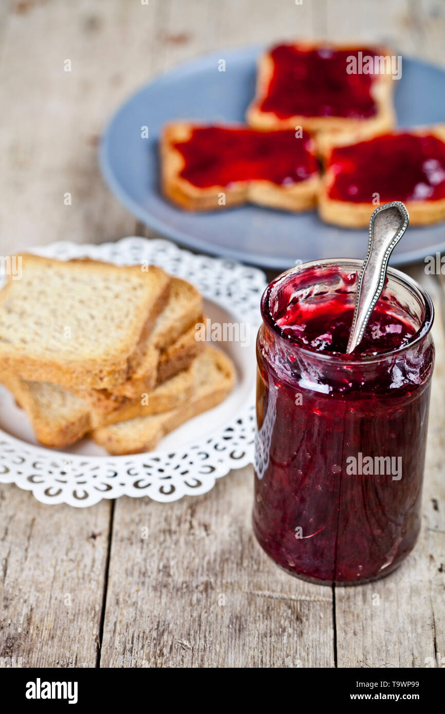 Homemade cherry jam and fresh toasted cereal bread slices plates ...