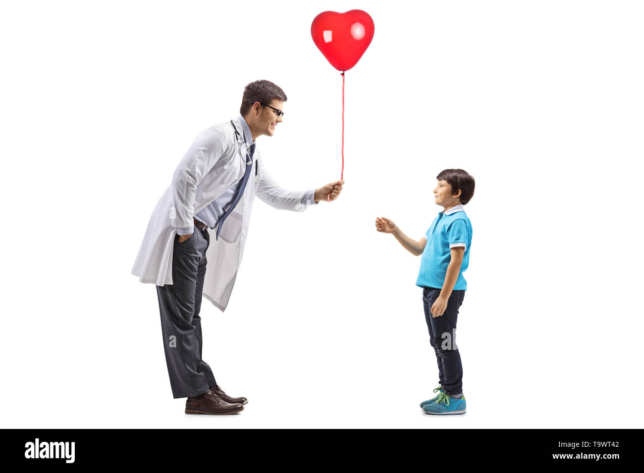 Full length profile shot of a male doctor giving a red heart balloon to ...