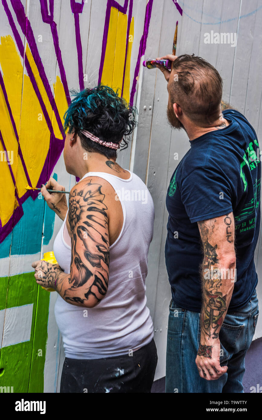 Artist paint mural on back alley fence Stock Photo - Alamy