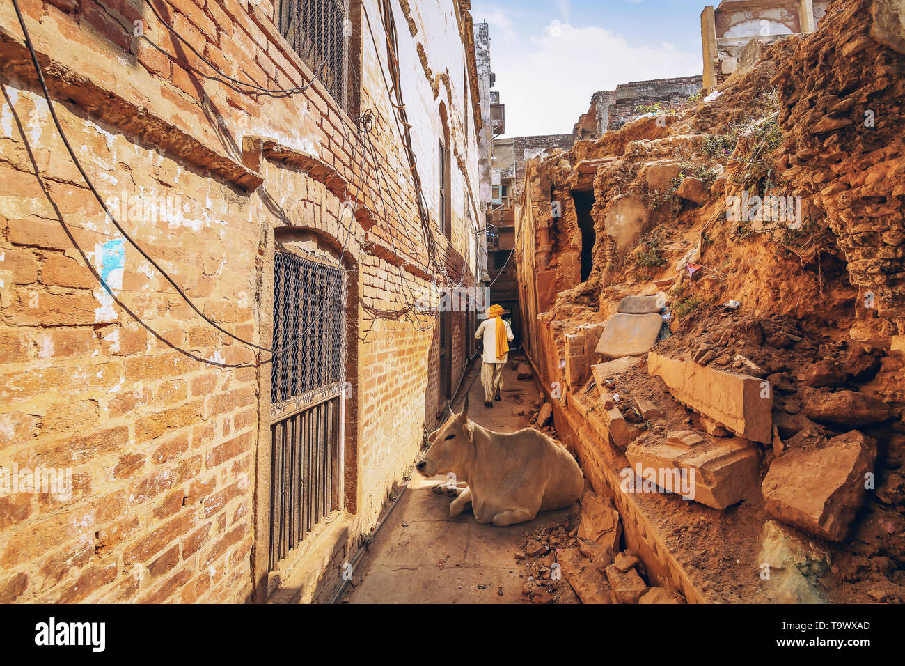 Varanasi narrow alleyway with ancient weathered buildings with view of ...