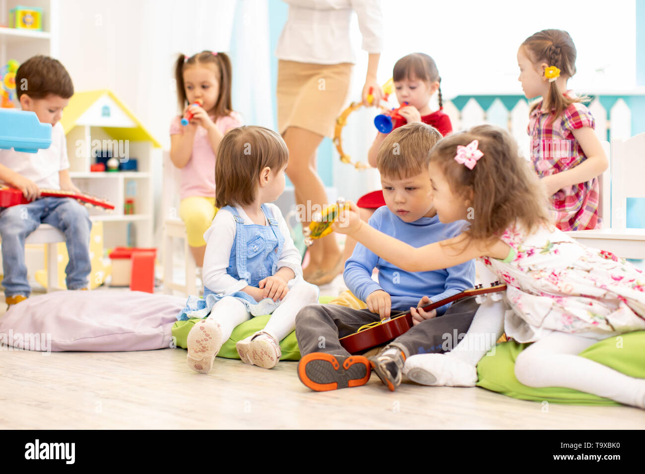 Group of kids playing with musical instruments in daycare Stock Photo ...