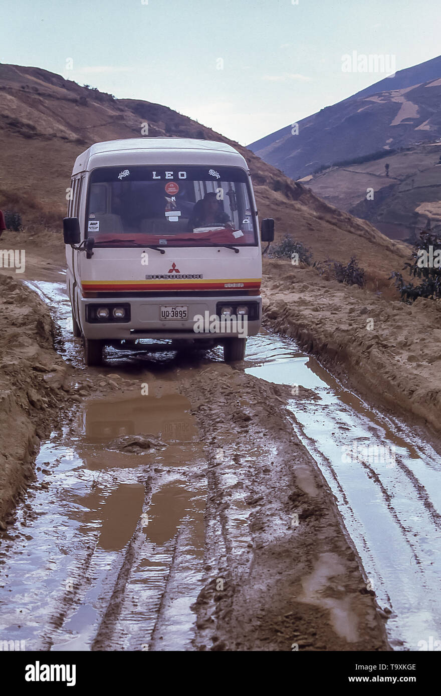 A small tourist bus faces a challenging pass in the Andean mountains ...
