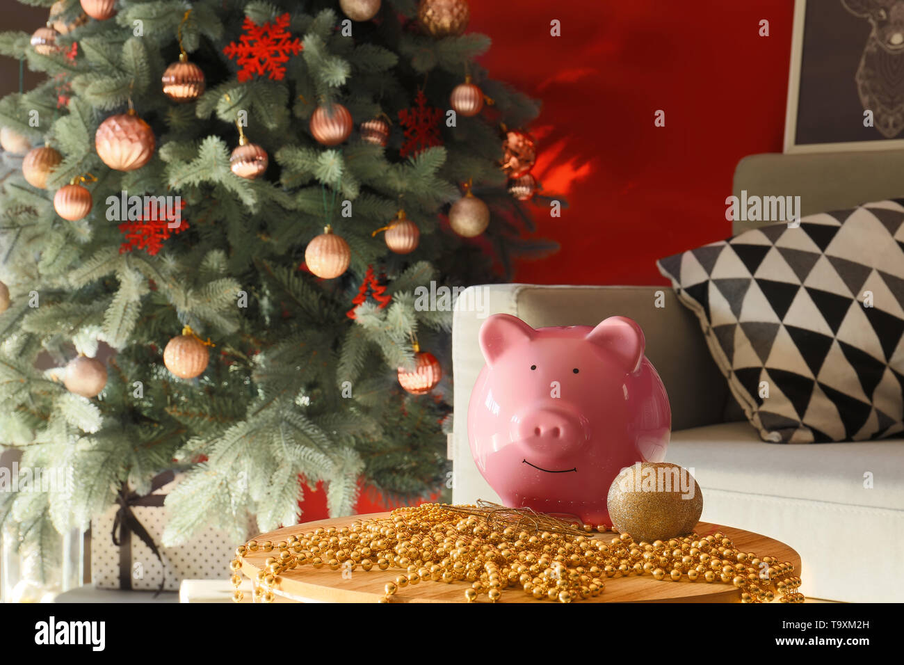 Cute piggy bank on table in room decorated for Christmas Stock Photo ...