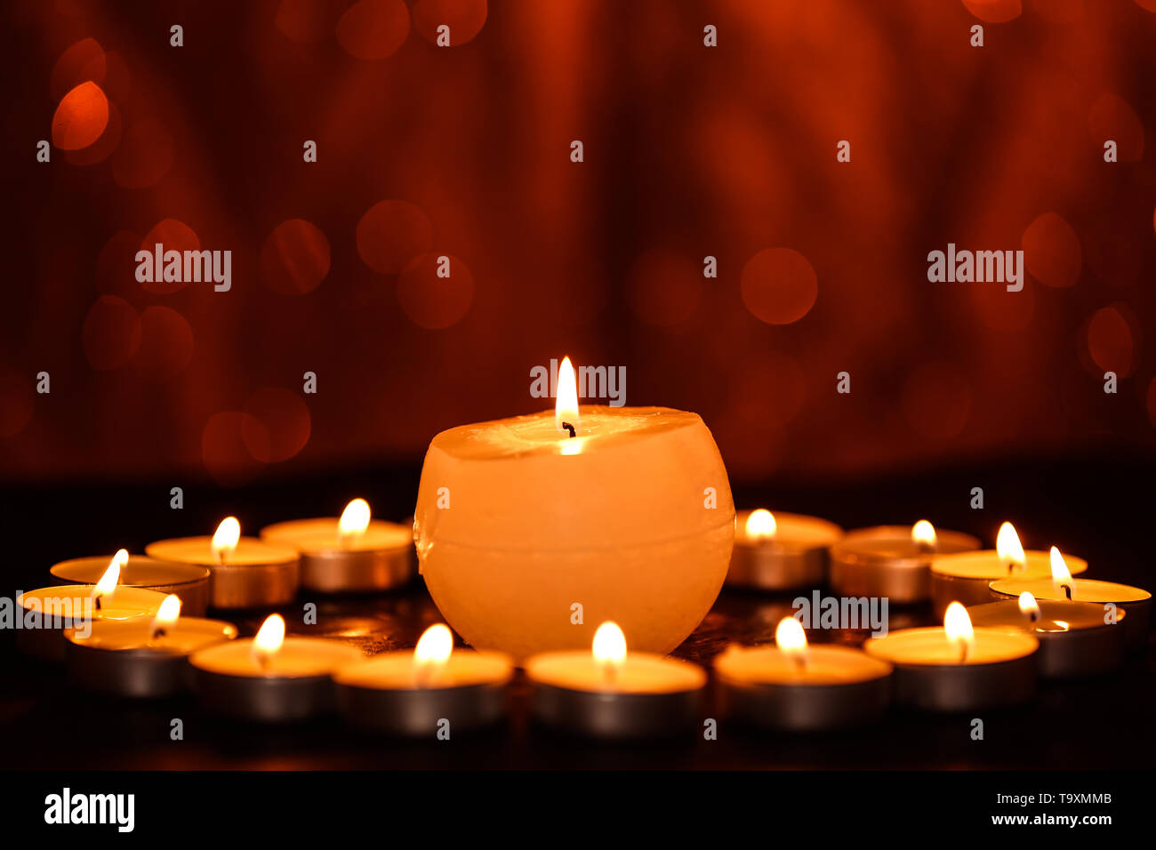 Beautiful burning candles on table against dark background Stock Photo ...