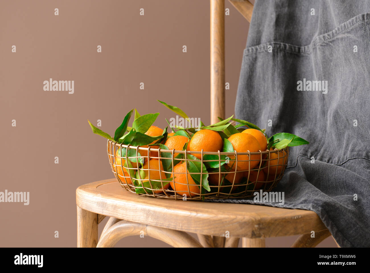 Basket with tasty tangerines on chair Stock Photo - Alamy