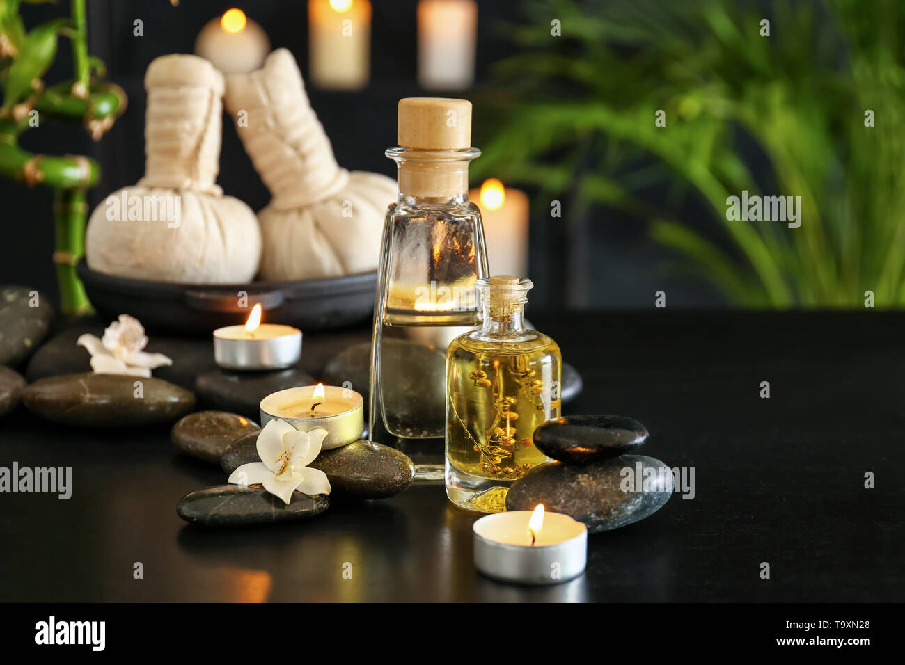 Essential oil, spa stones and candles on dark background Stock Photo ...
