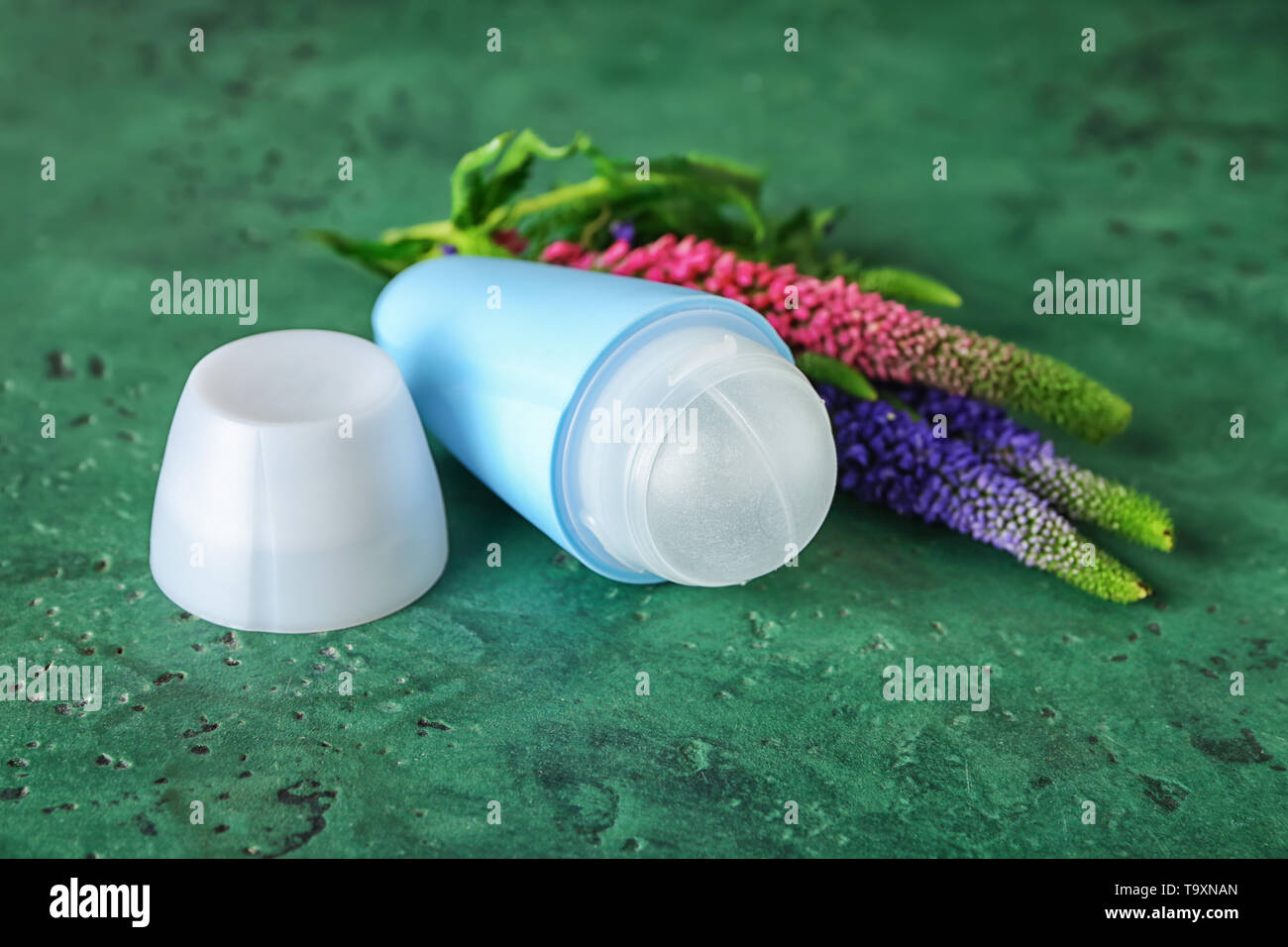 Deodorant and flowers on color background Stock Photo - Alamy
